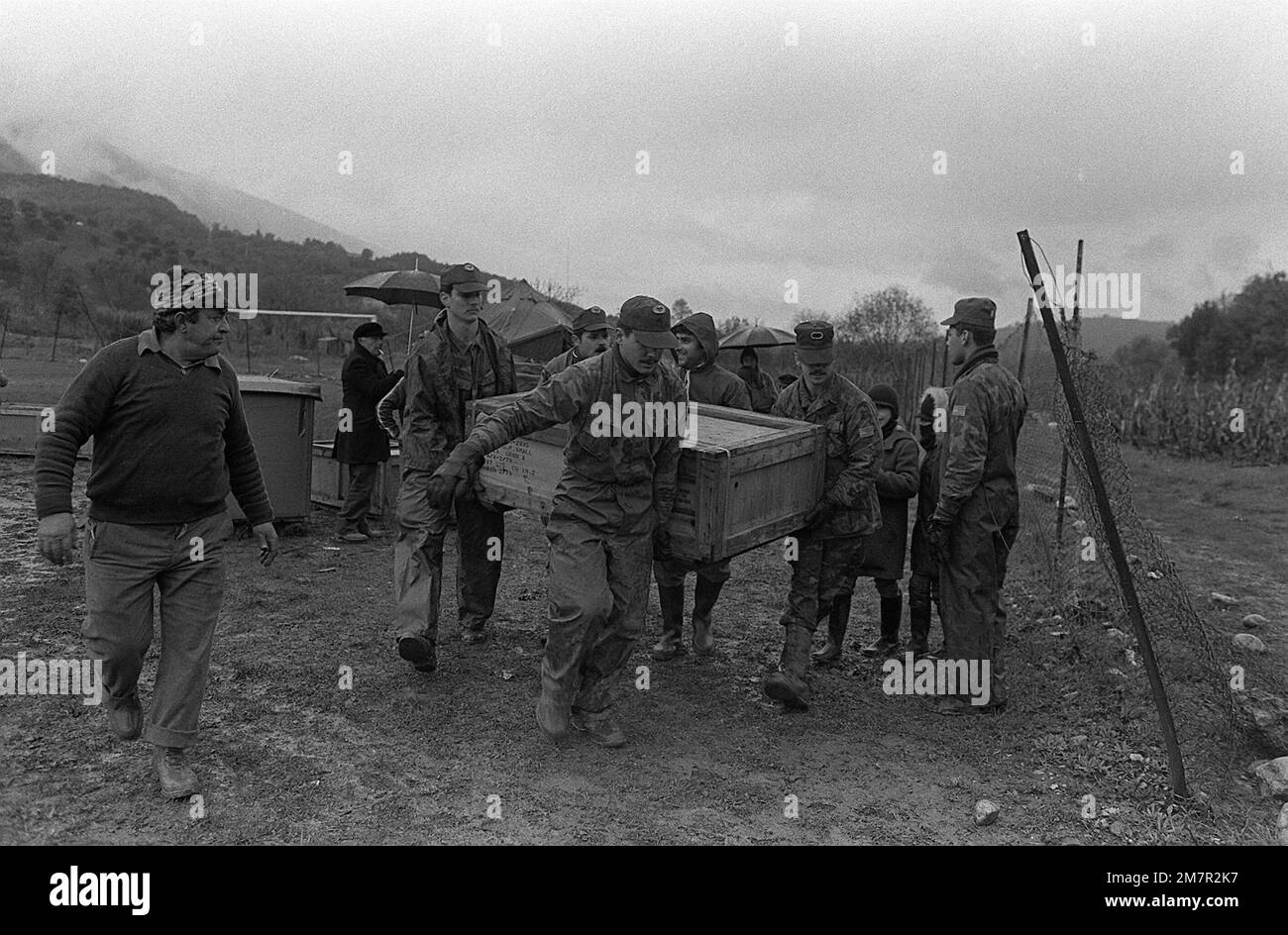AN Army relief team carries an Army tent in a box to a waiting truck ...