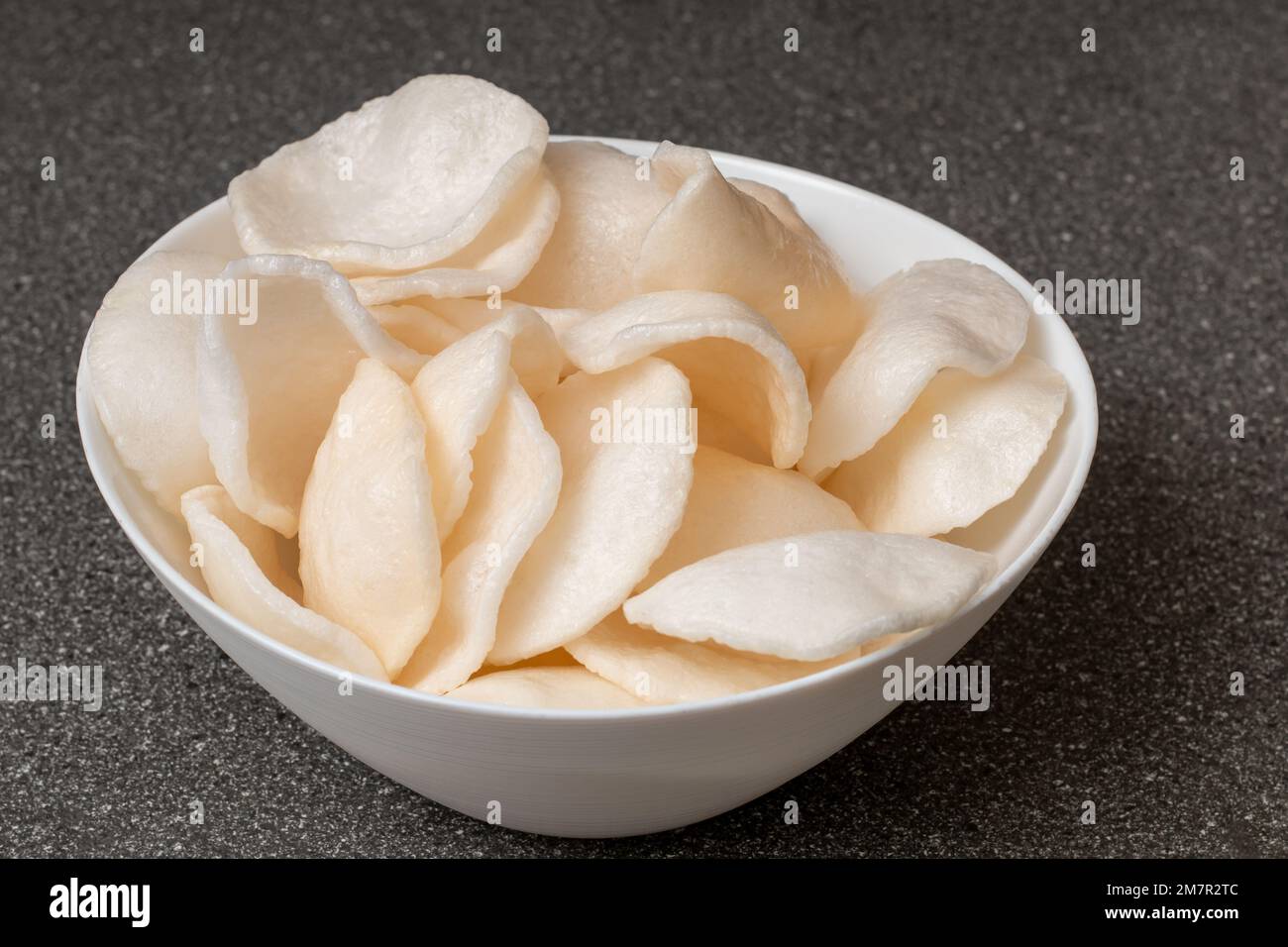 Cooked rice chips in bowl - Grey background Stock Photo - Alamy
