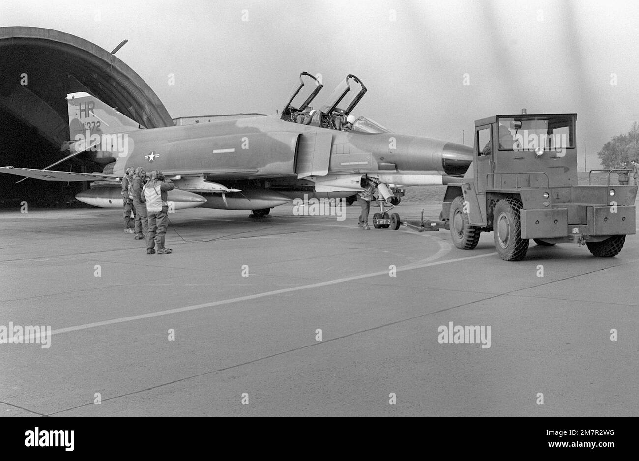 A ground crew in chemical warfare gear prepares an F-4 Phantom II ...