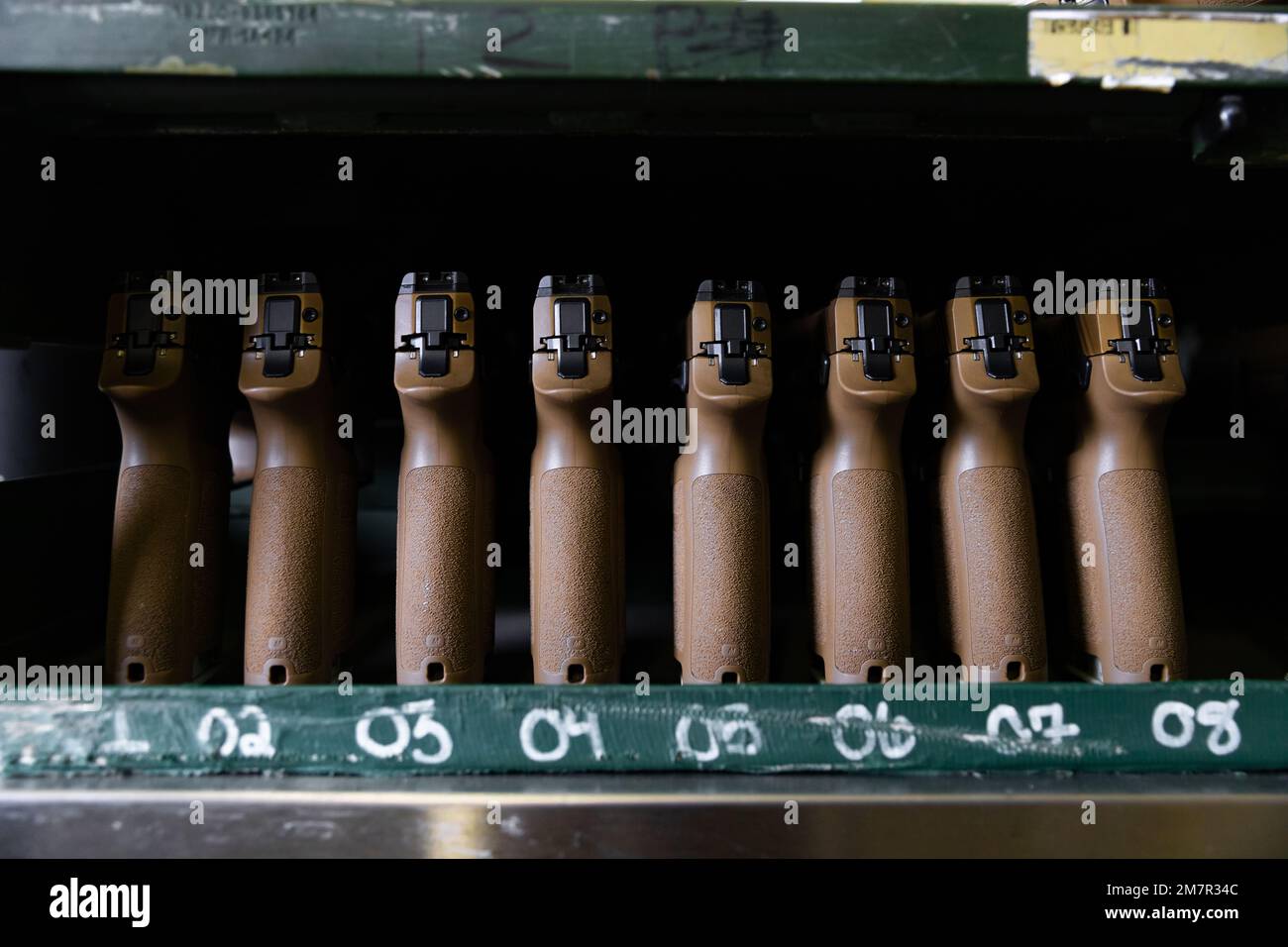 Multiple M17 service pistols are secured in a weapon's rack at Joint ...