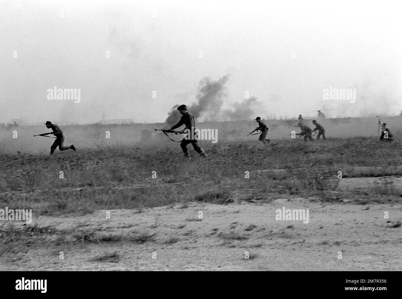 Personnel go across a field during base counterinsurgency training at ...