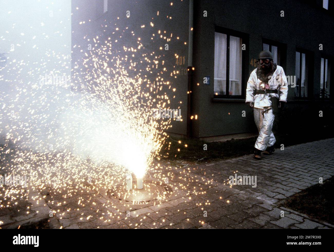 A fireman dressed in chemical warfare gear responds to a simulated fire ...