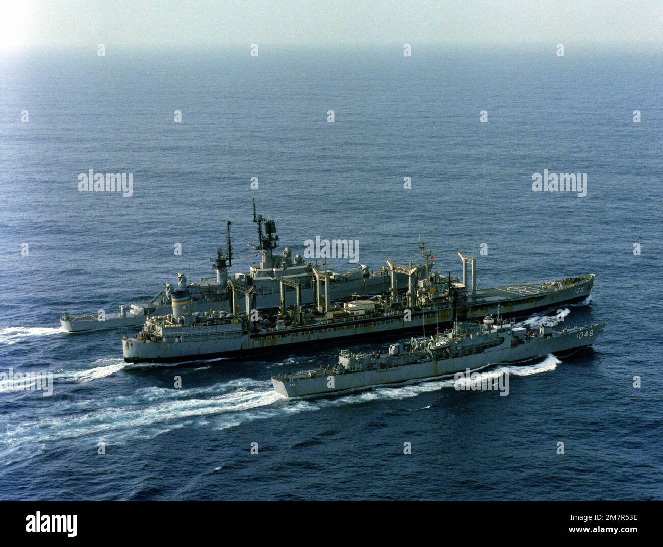 An aerial starboard quarter view of, front to back: the frigate USS ...