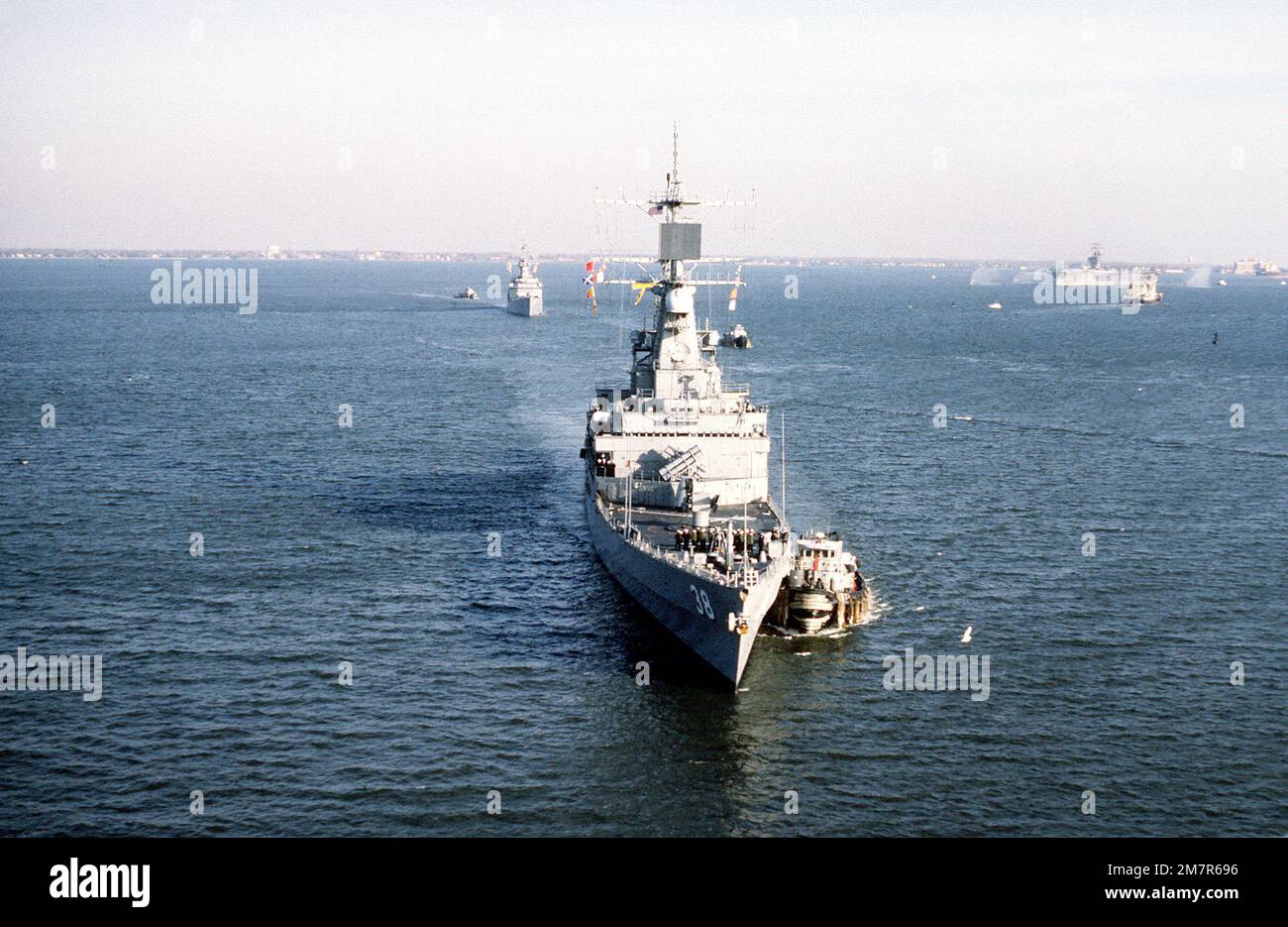 Aerial bow view of the nuclear-powered aircraft carrier USS VIRGINIA (CGN-38) being assisted by ...