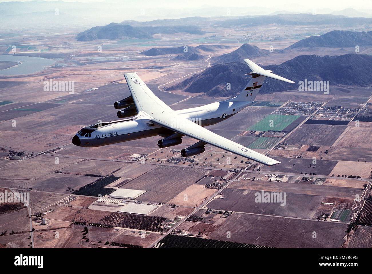 AN air-to-air left front view of a C-141B Starlifter aircraft over ...