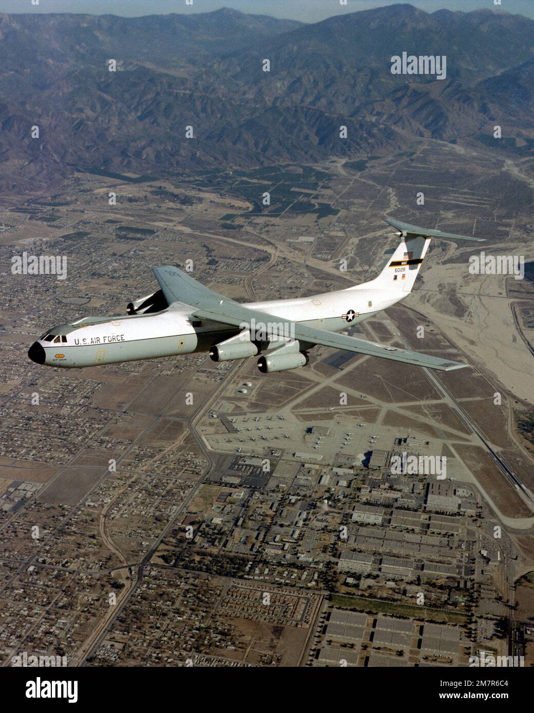 An air-to-air left side view of a C-141 Starlifter aircraft over Norton ...