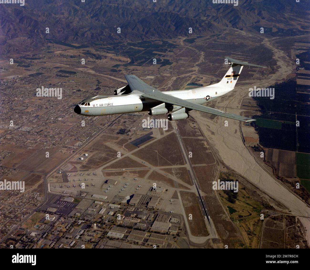 An air-to-air left side view of a C-141 Starlifter aircraft over Norton ...