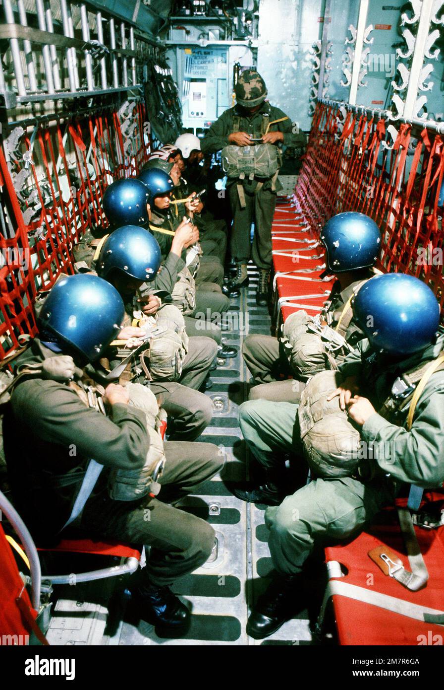 Philippine army troops make final checks on their parachute equipment ...