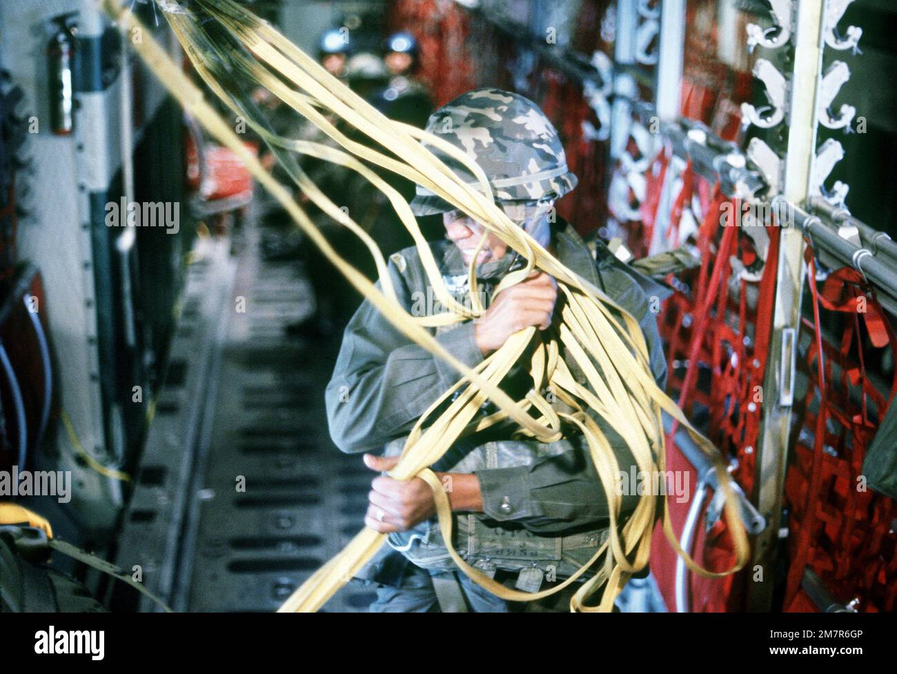 A Philippine army jumpmaster gathers static cords during an airdrop ...
