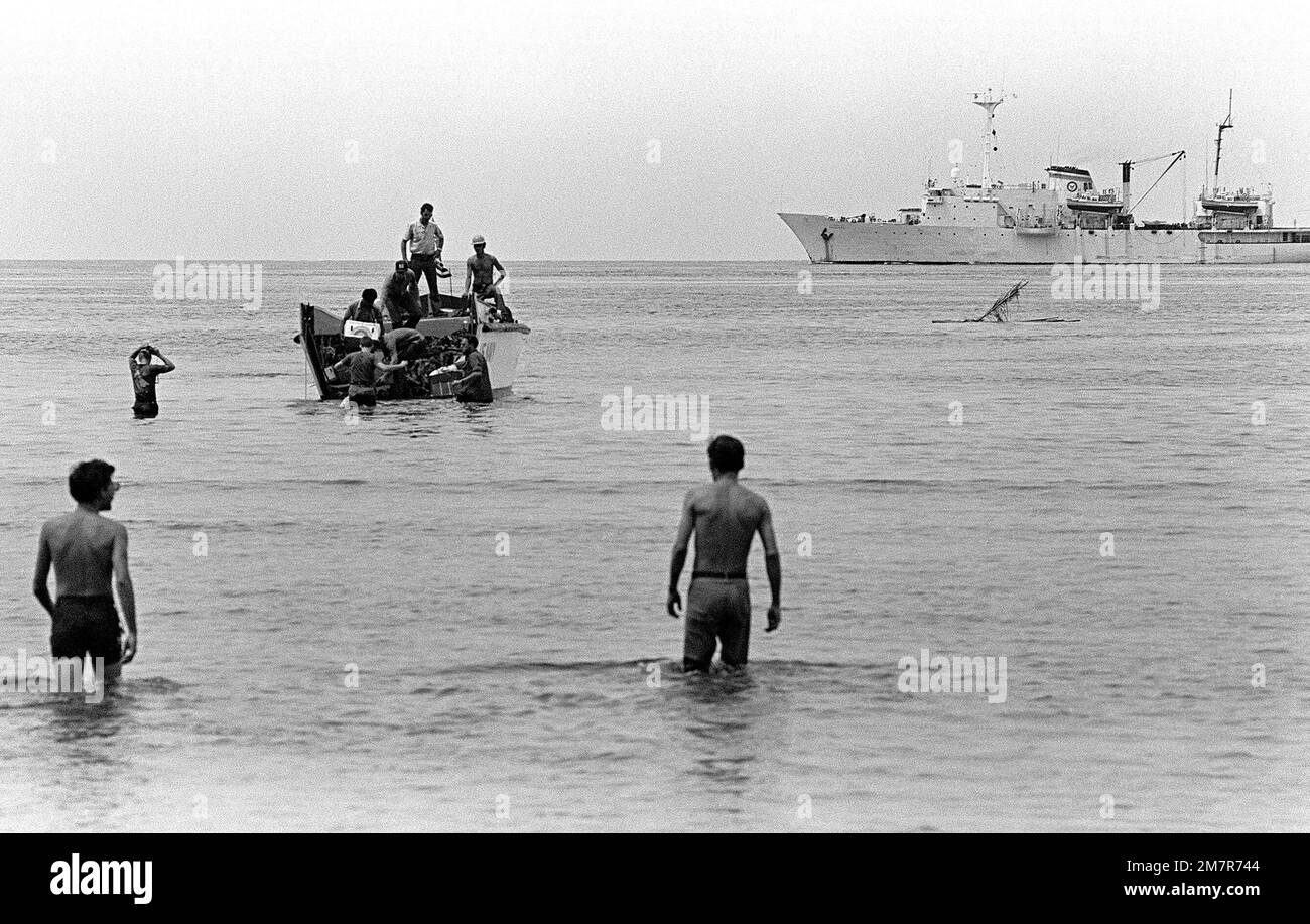 Supplies are carried ashore from the surveying ship USNS CHAUVENET (T ...
