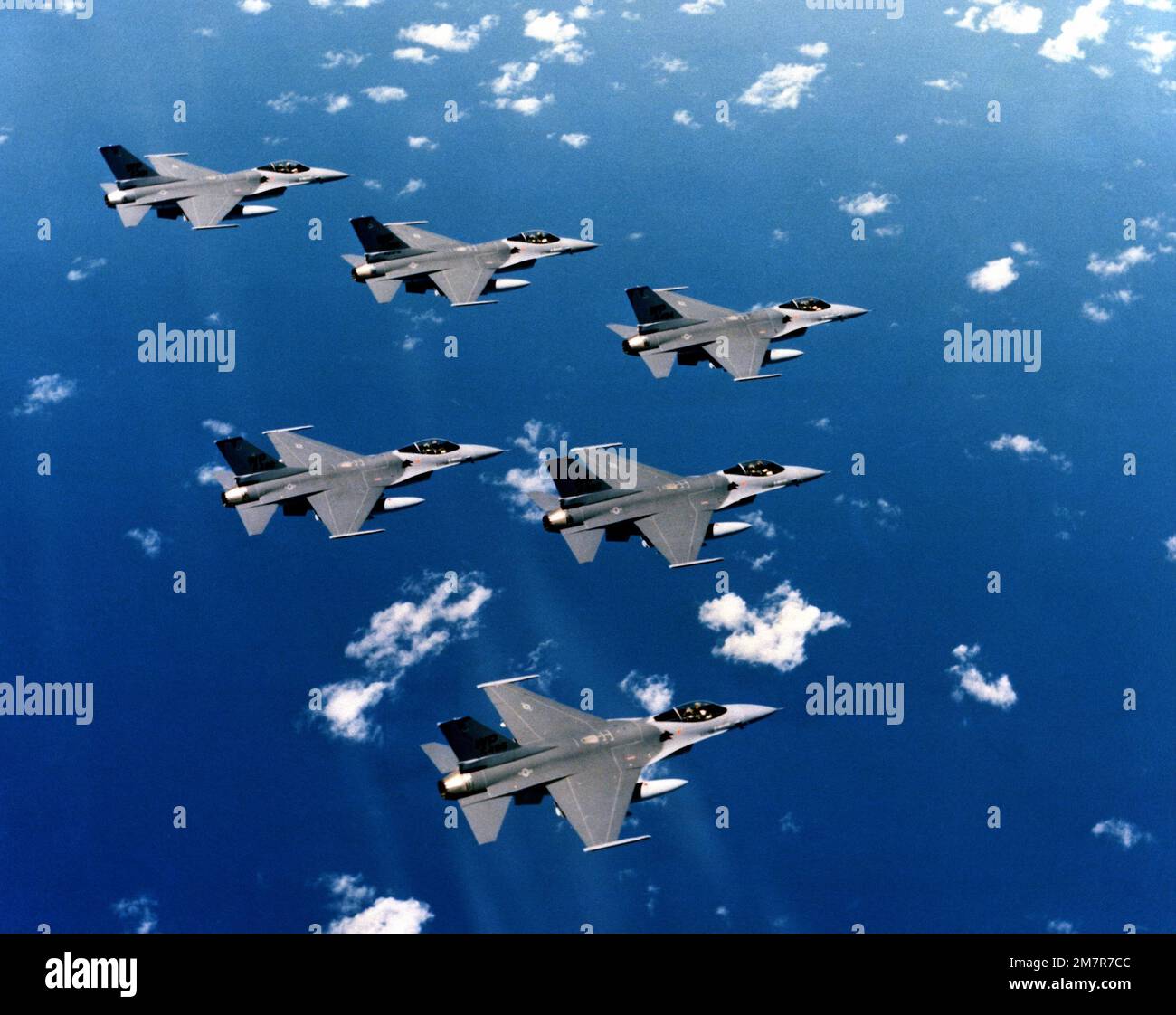 An air-to-air right rear view of a six-ship delta formation of F-16A ...