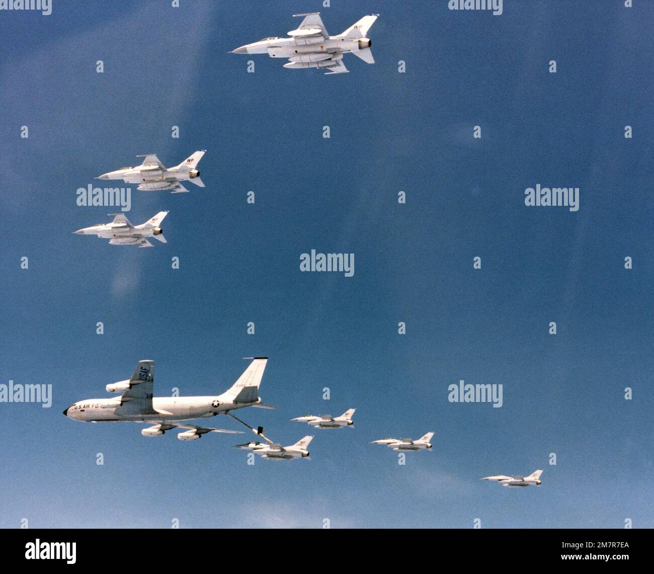 A left side view of a KC-135 Stratotanker aircraft refueling an F-16A ...