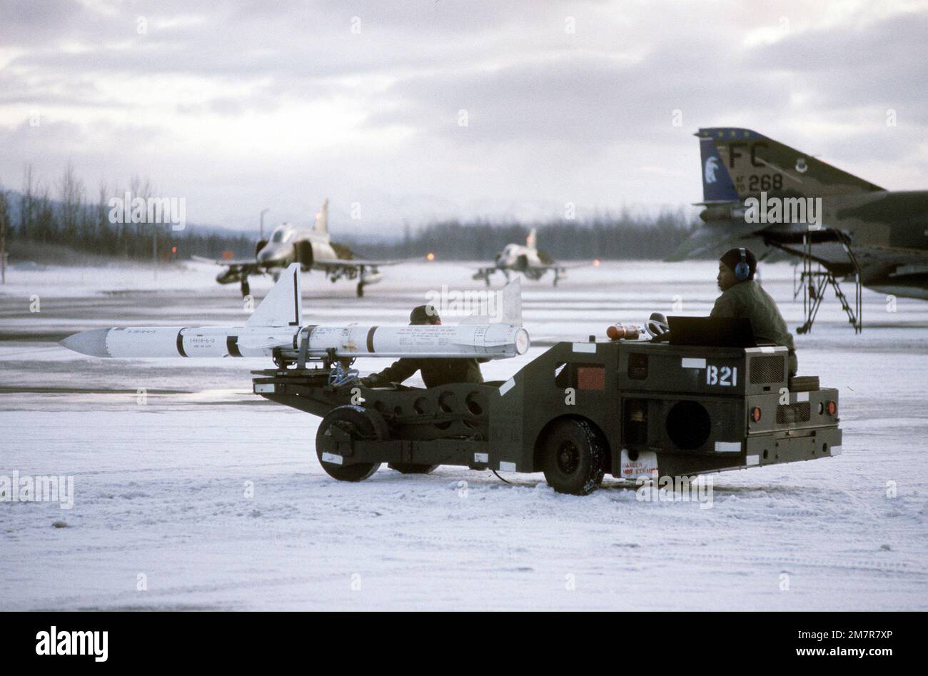 AN AIM-7 Sparrow air-to-air missile, aboard a bomb loader, is being ...