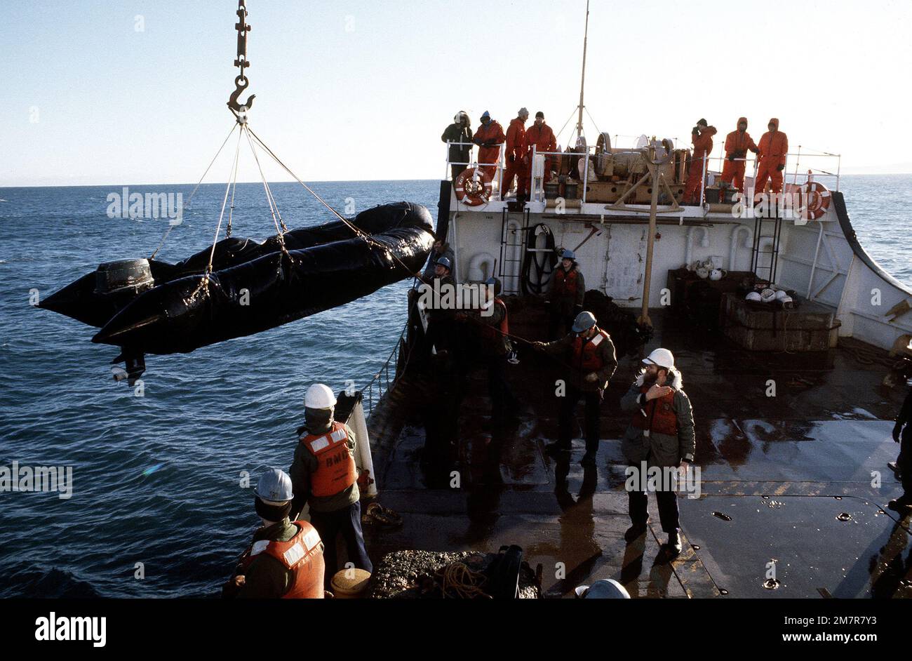 A rubber recovery boat is being reeled aboard the Coast Guard ship ...