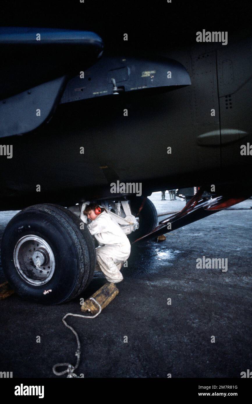 A ground crew chief inspects the landing gear of an F-111A aircraft ...