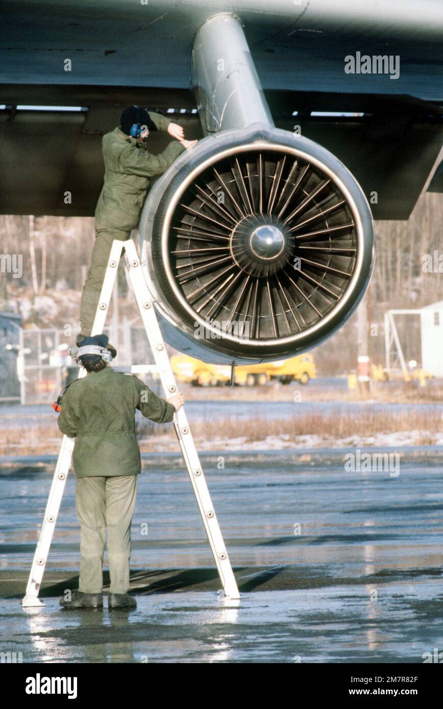 AN airman tightens the cowling of a C-141 Starlifter aircraft engine ...