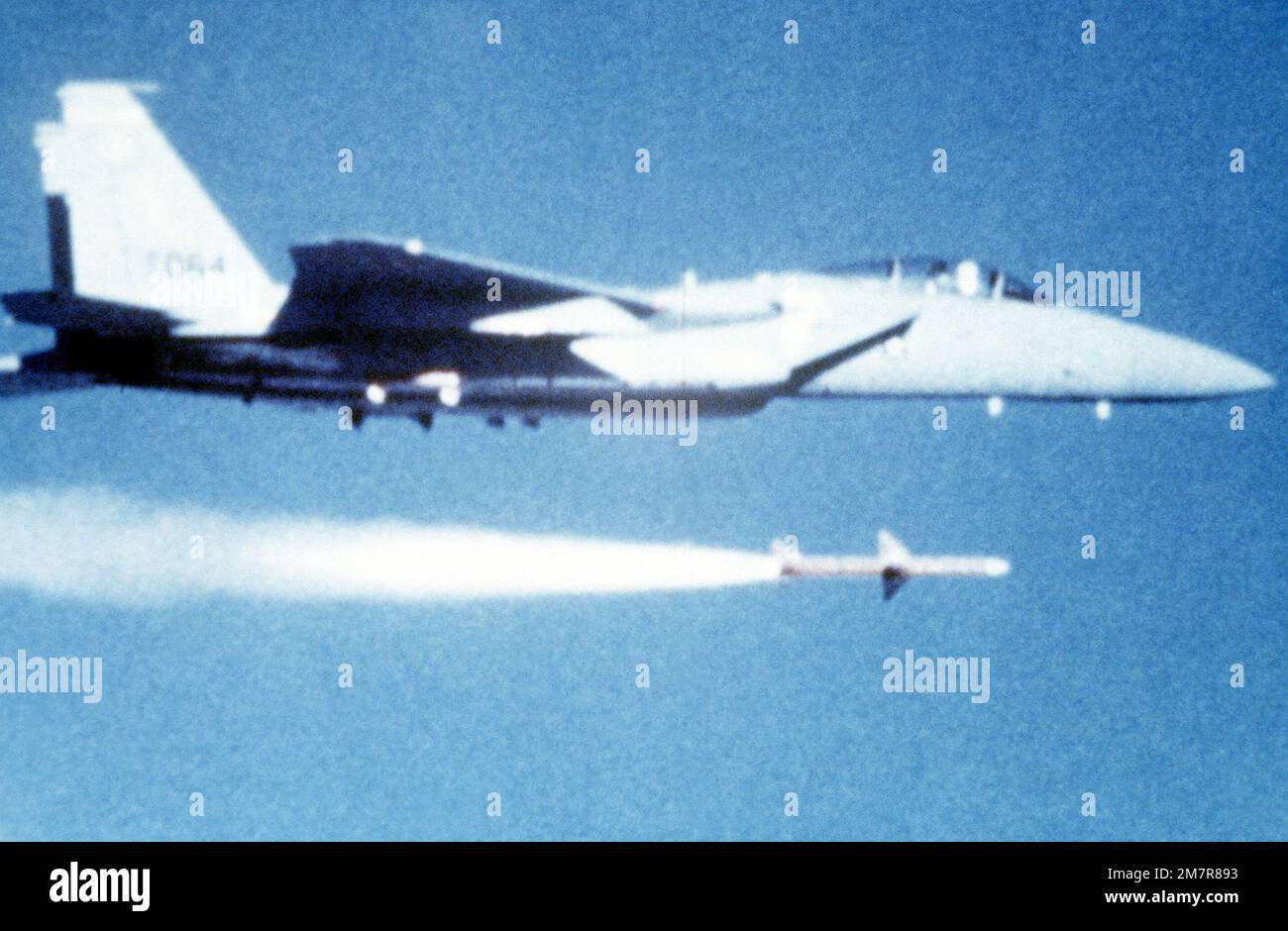 AN air-to-air view of an F-15 Eagle aircraft firing an AIM-7 Sparrow ...