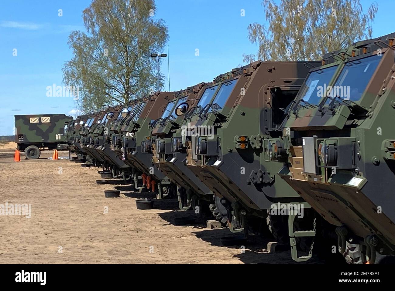 A line of M107 palletized load system transporters is prepared and ...