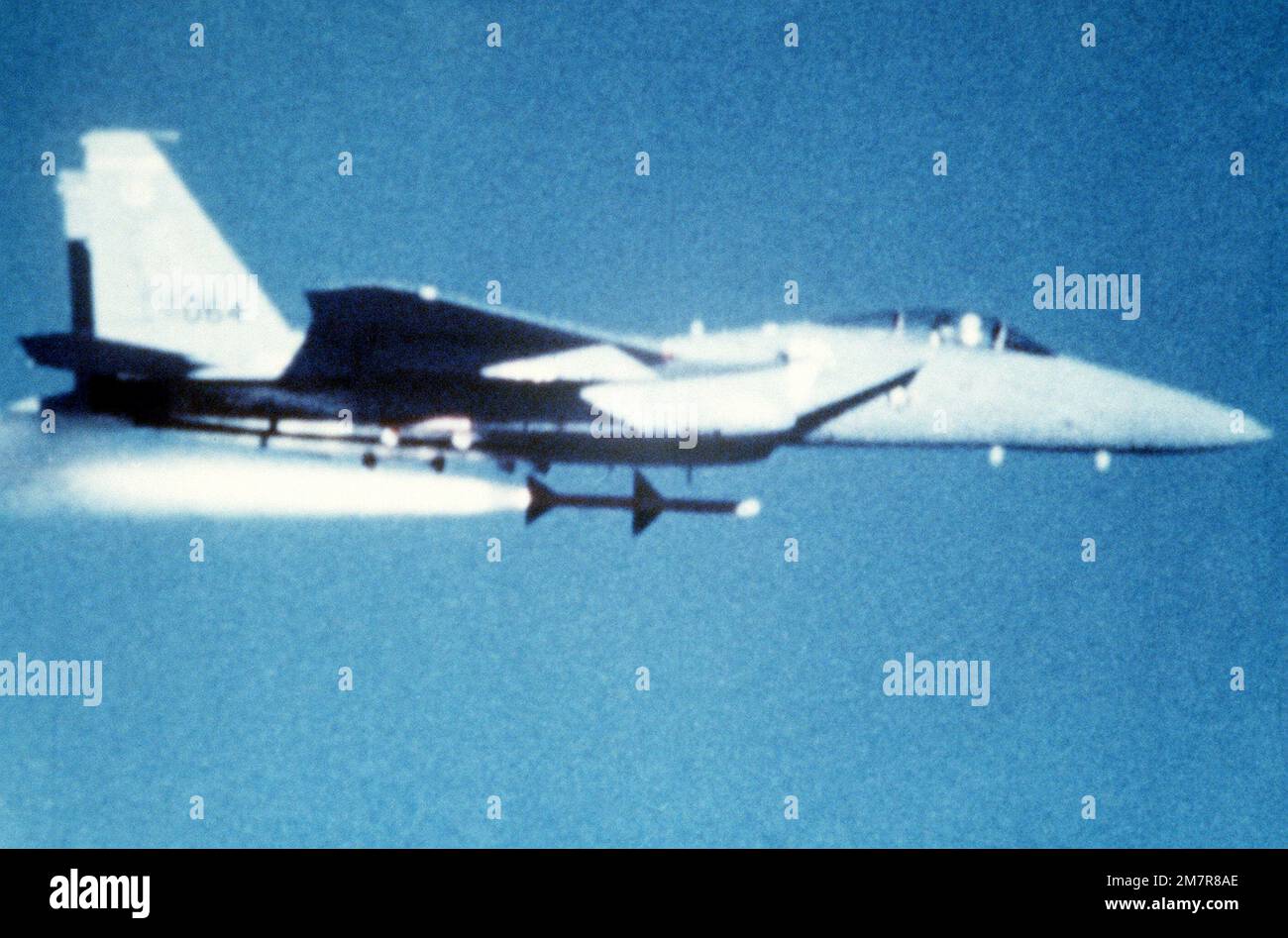 AN air-to-air right side view of an F-15 Eagle aircraft firing an AIM-7 ...