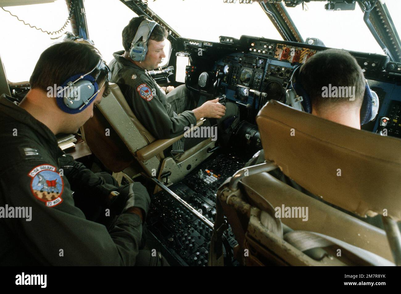 A view of the crew in the cockpit of a C-5 Galaxy as they fly their ...