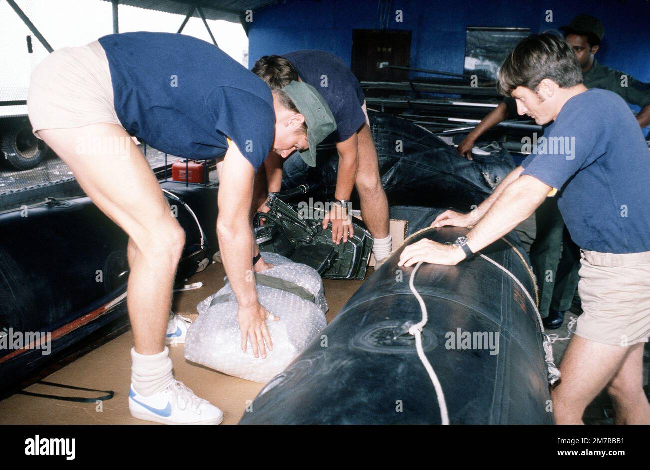 An outboard motor is stored in a rubber raft as preparations are made ...