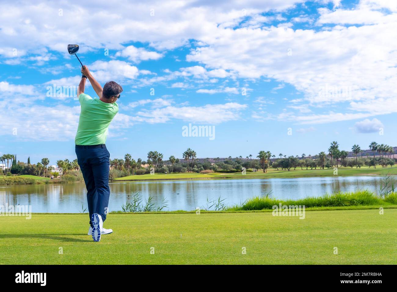 Male golf player on professional golf course. Golfer hitting the ball ...