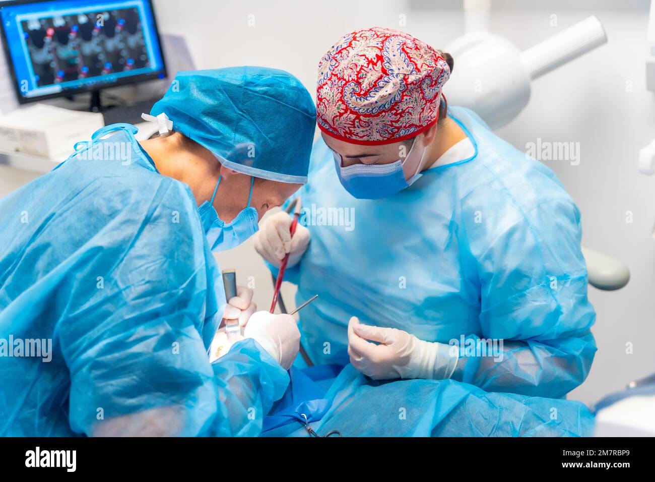 Dental clinic, dentist doctor and the assistant in blue operation suits ...