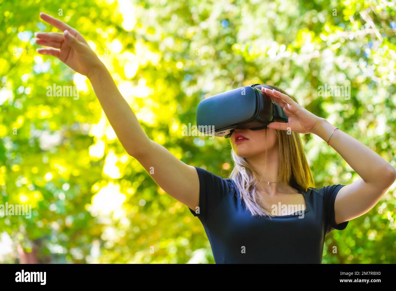 Woman with virtual reality glasses enjoying nature, imagining herself ...