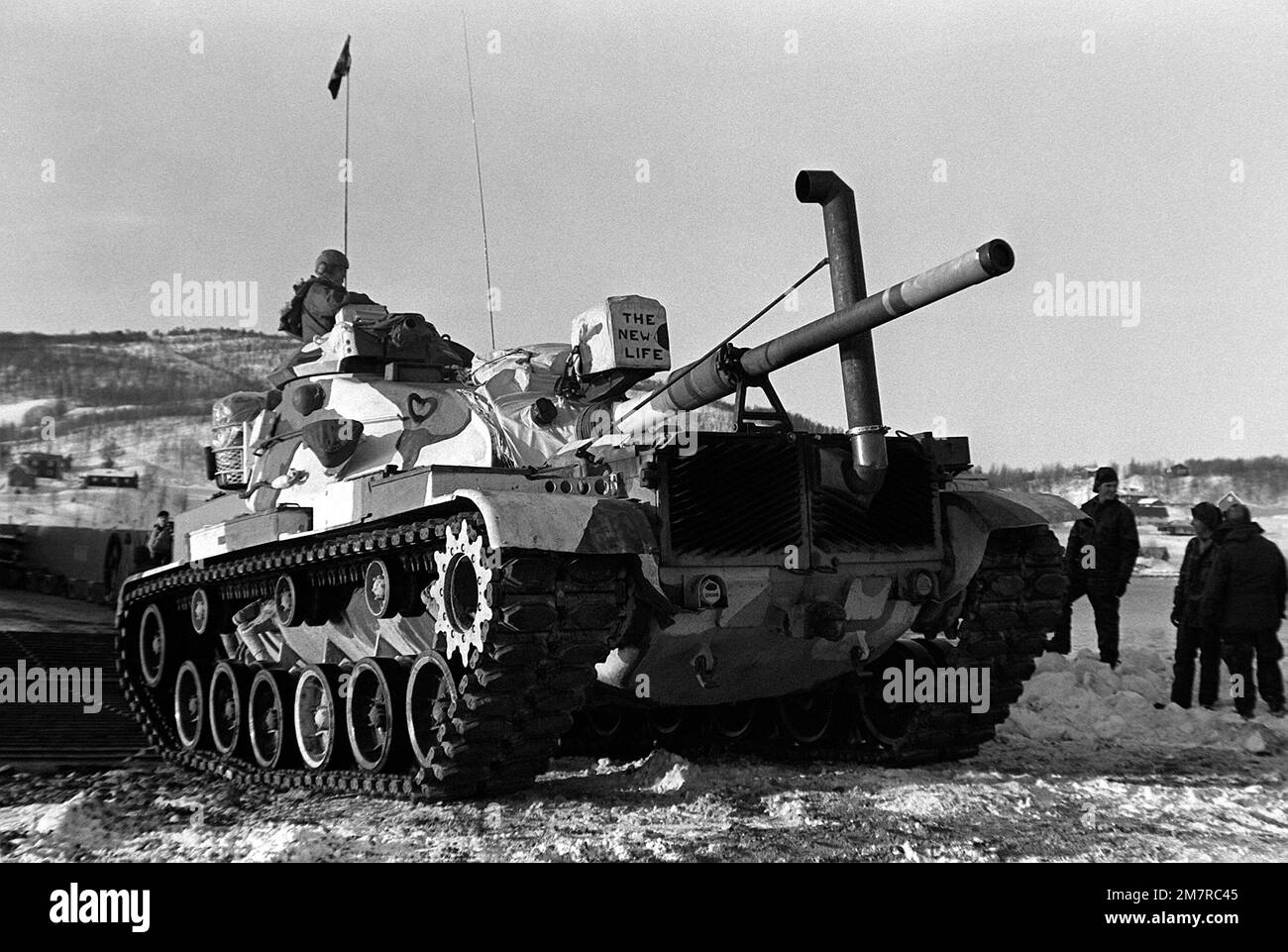 An M-60A1 tank is driven to the staging area after unloading from an ...