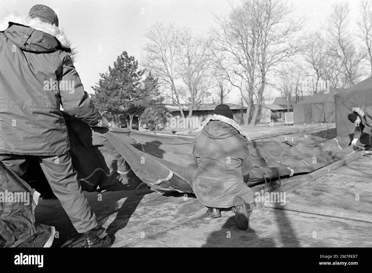 Members of the 554th Civil Engineering Squadron lay out tents that are ...