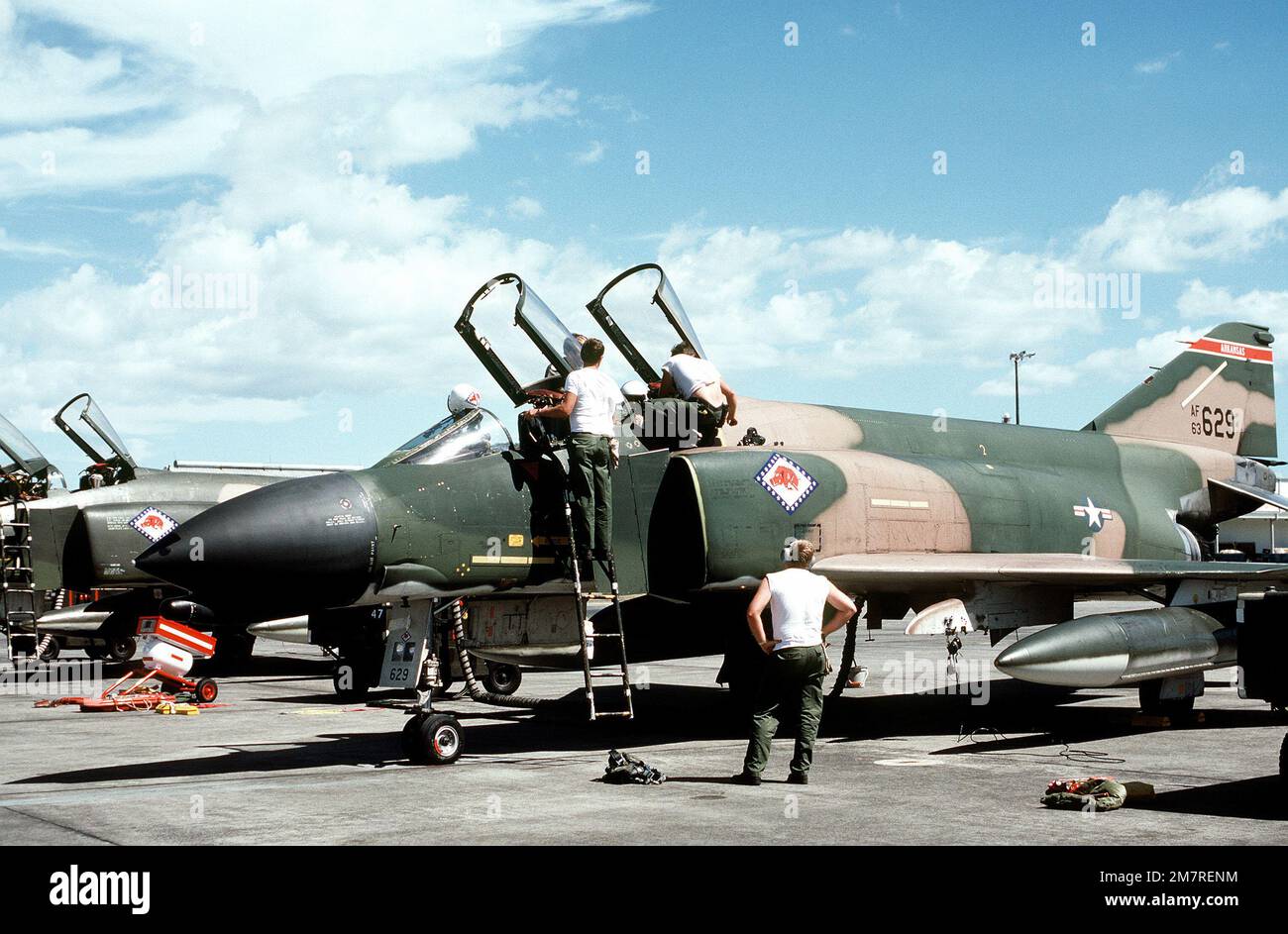 Crew members perform maintenance on an F-4 Phantom II aircraft during ...