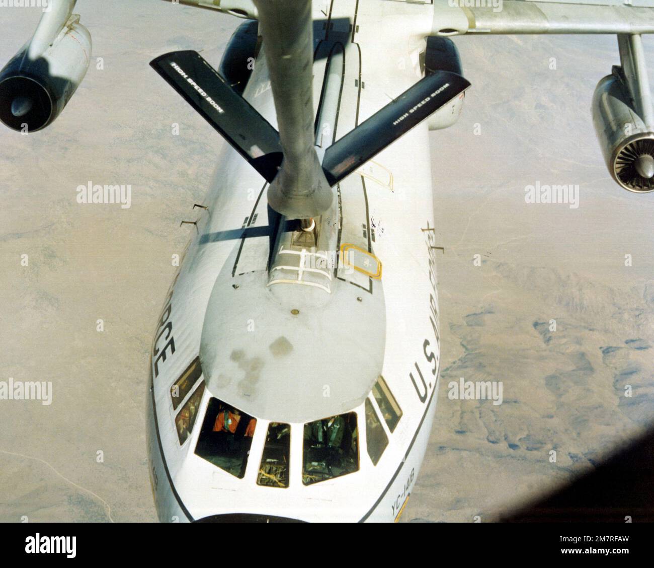 An air-to-air front view of a C-141B Starlifter aircraft being refueled ...