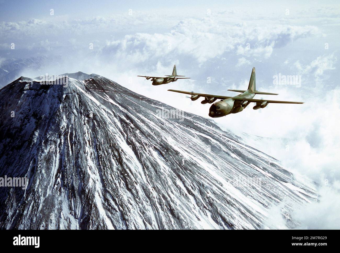 Two C-130 Hercules aircraft fly in formation near the peak of Mount Fuji. Base: Mount Fuji ...