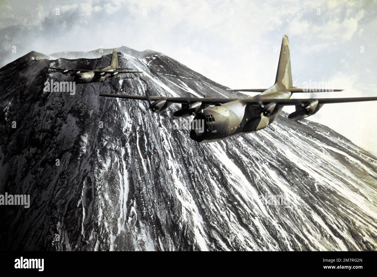 Two C-130 Hercules aircraft fly slightly different formations near the ...