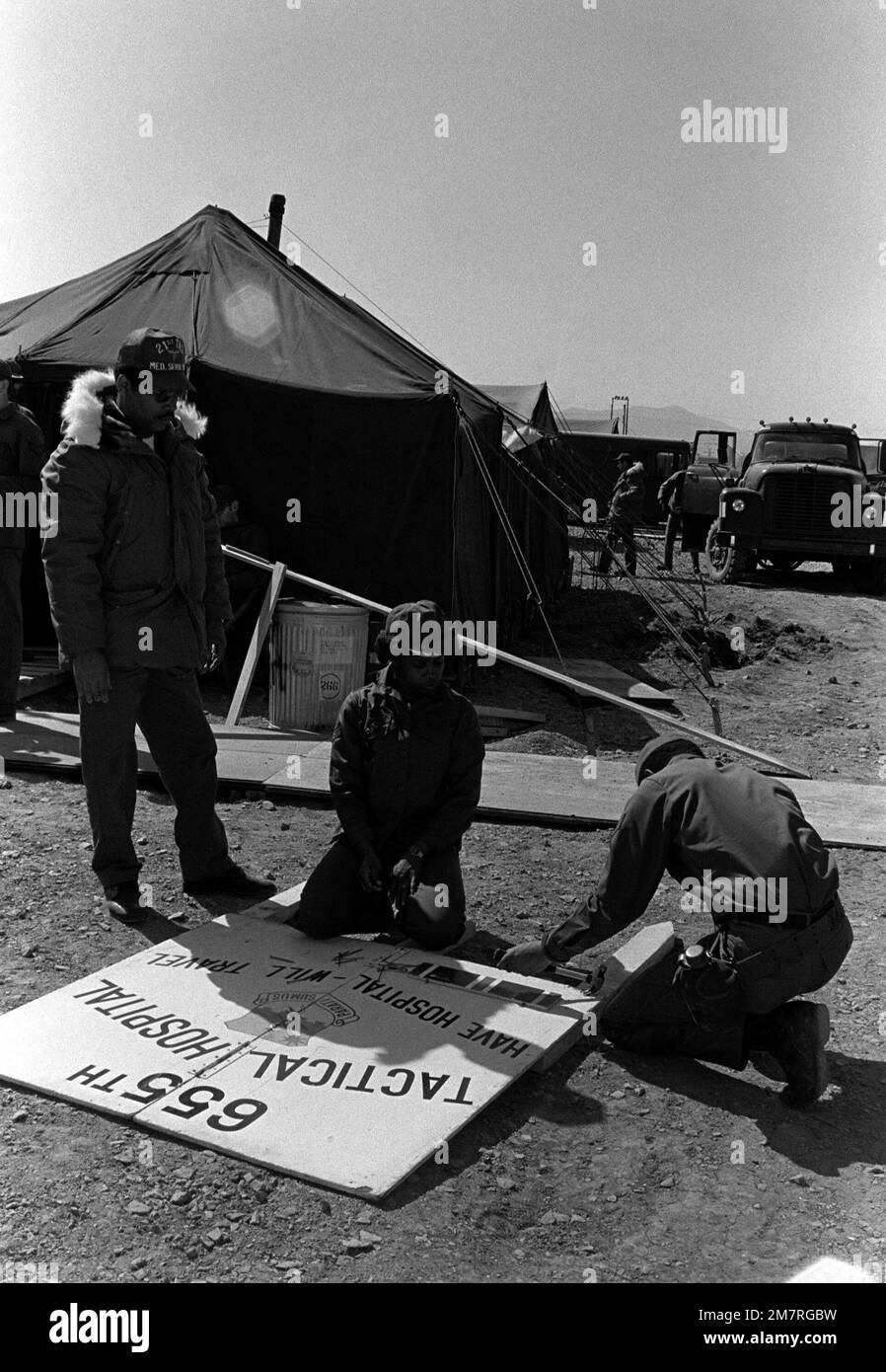 Airmen prepare a squadron sign for set-up in the tent city during ...