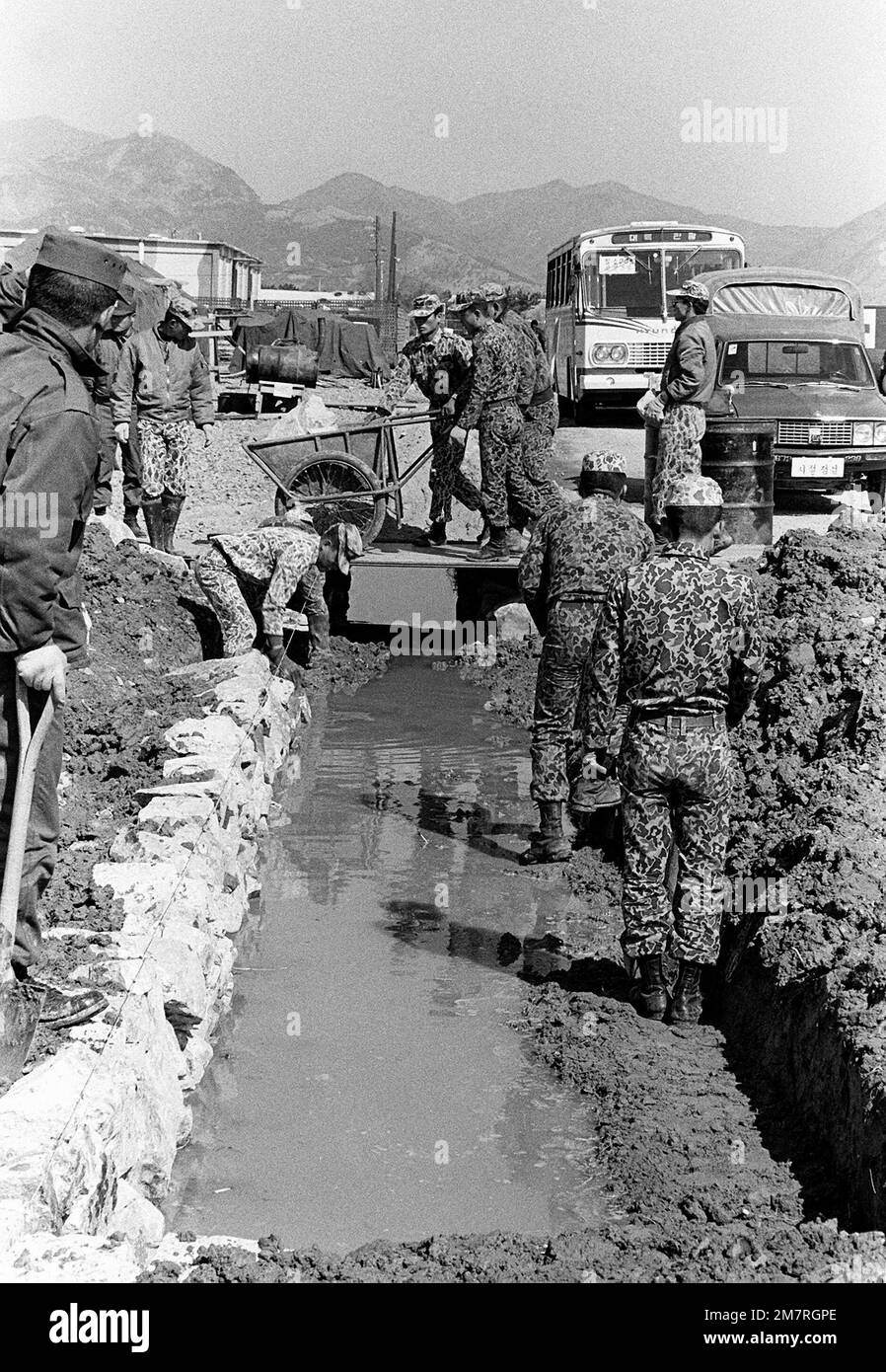Korean Air Force members build a drainage ditch in the tent city during ...