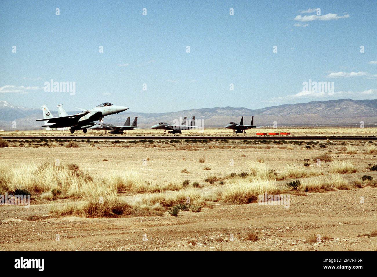 An F-15 Eagle aircraft lands as the other Eagles wait for clearance for ...