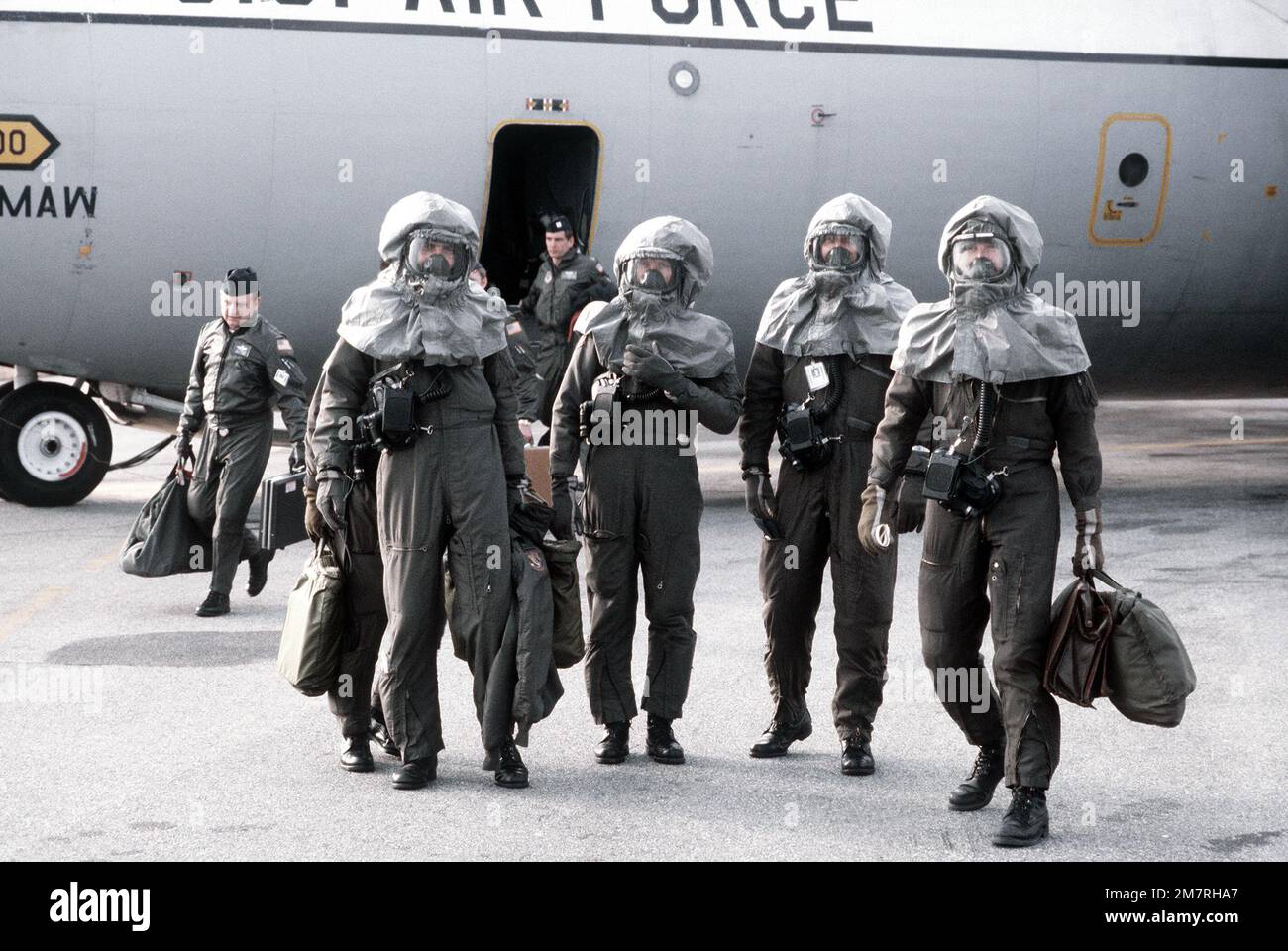 The flight crew pauses at the end of a chemical warfare exercise. The ...
