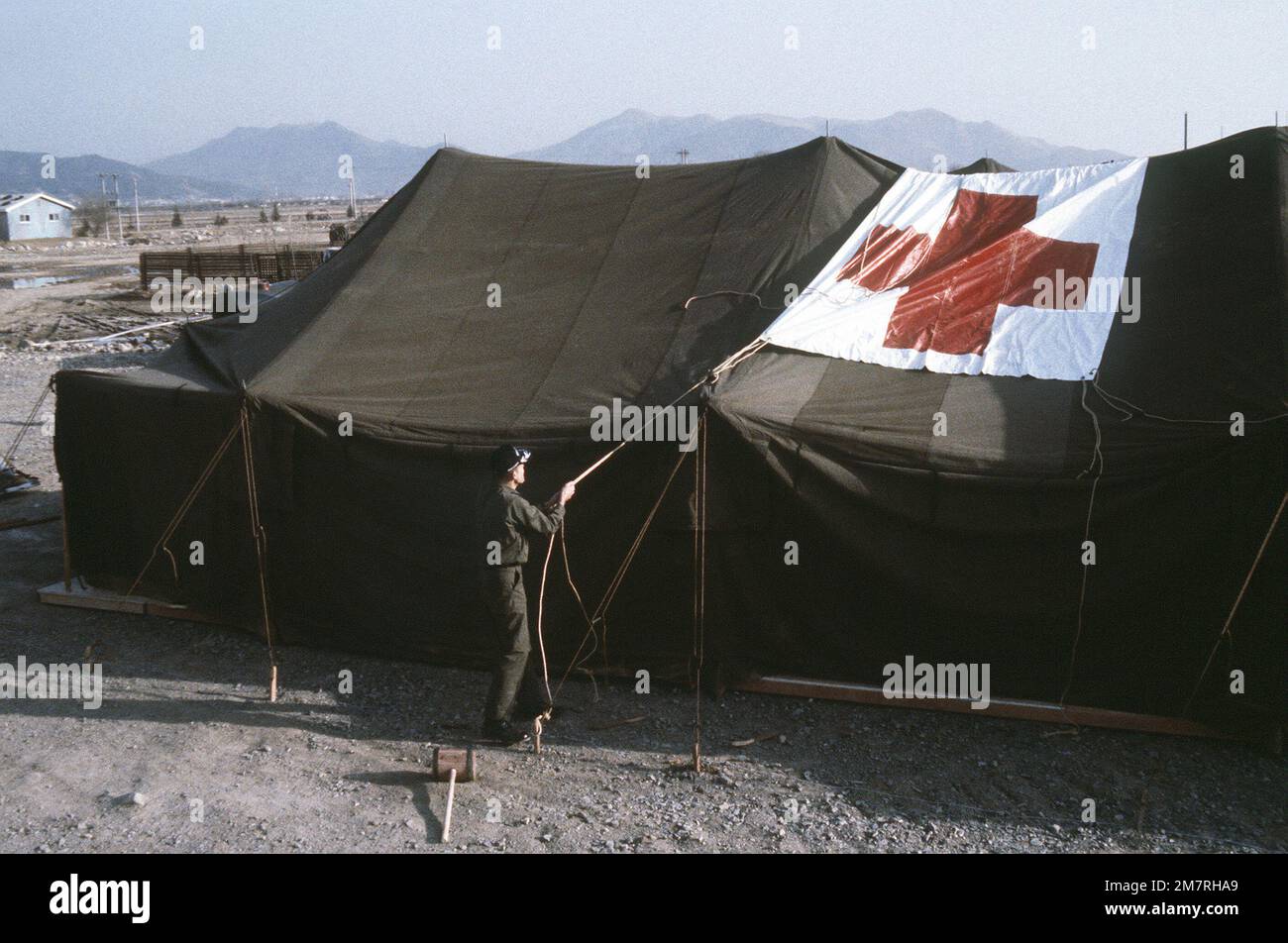 A 655th Tactical Field Hospital Squadron member marks a hospital tent ...