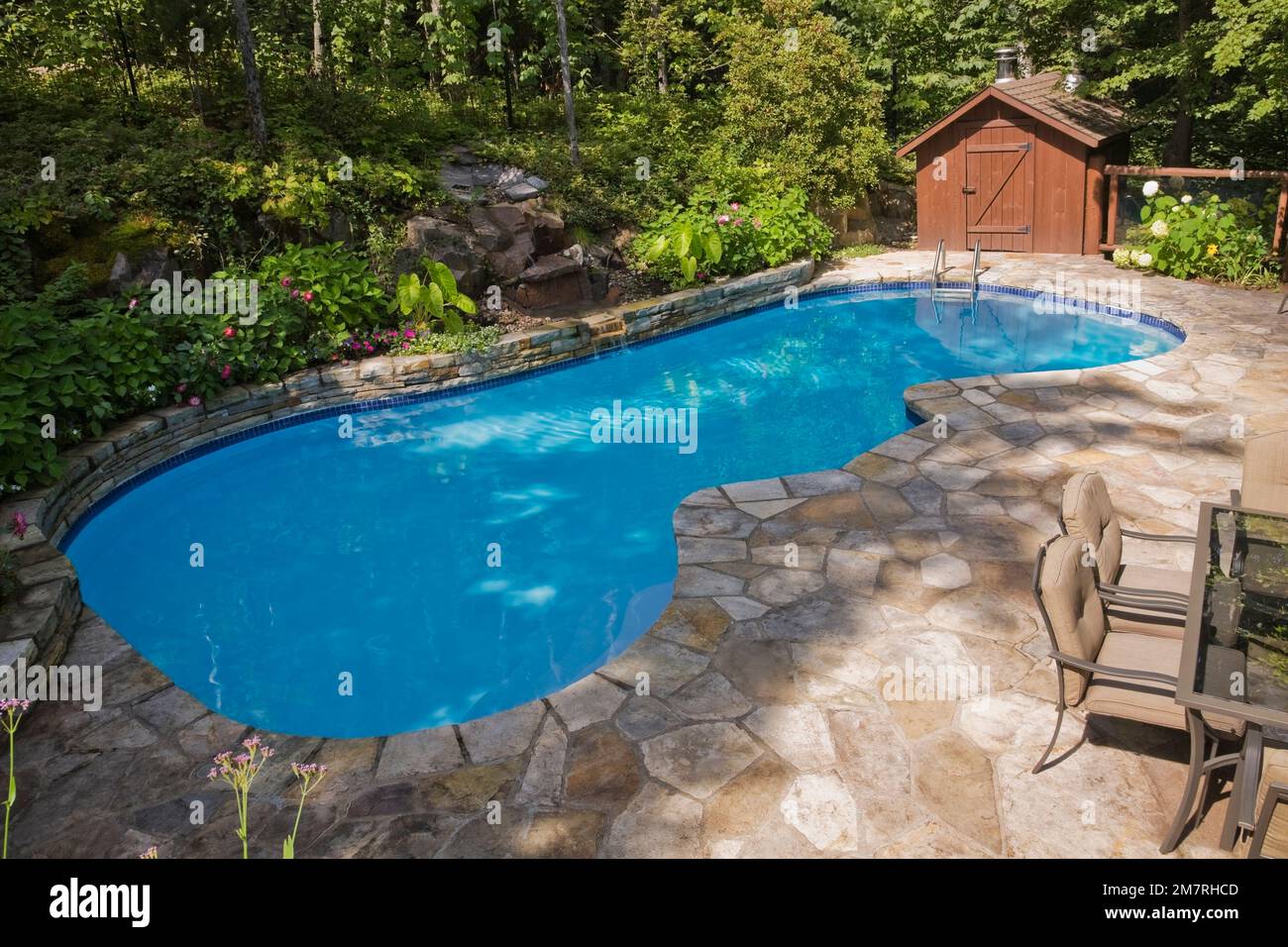 In ground swimming pool with waterfall and flagstone decking in ...