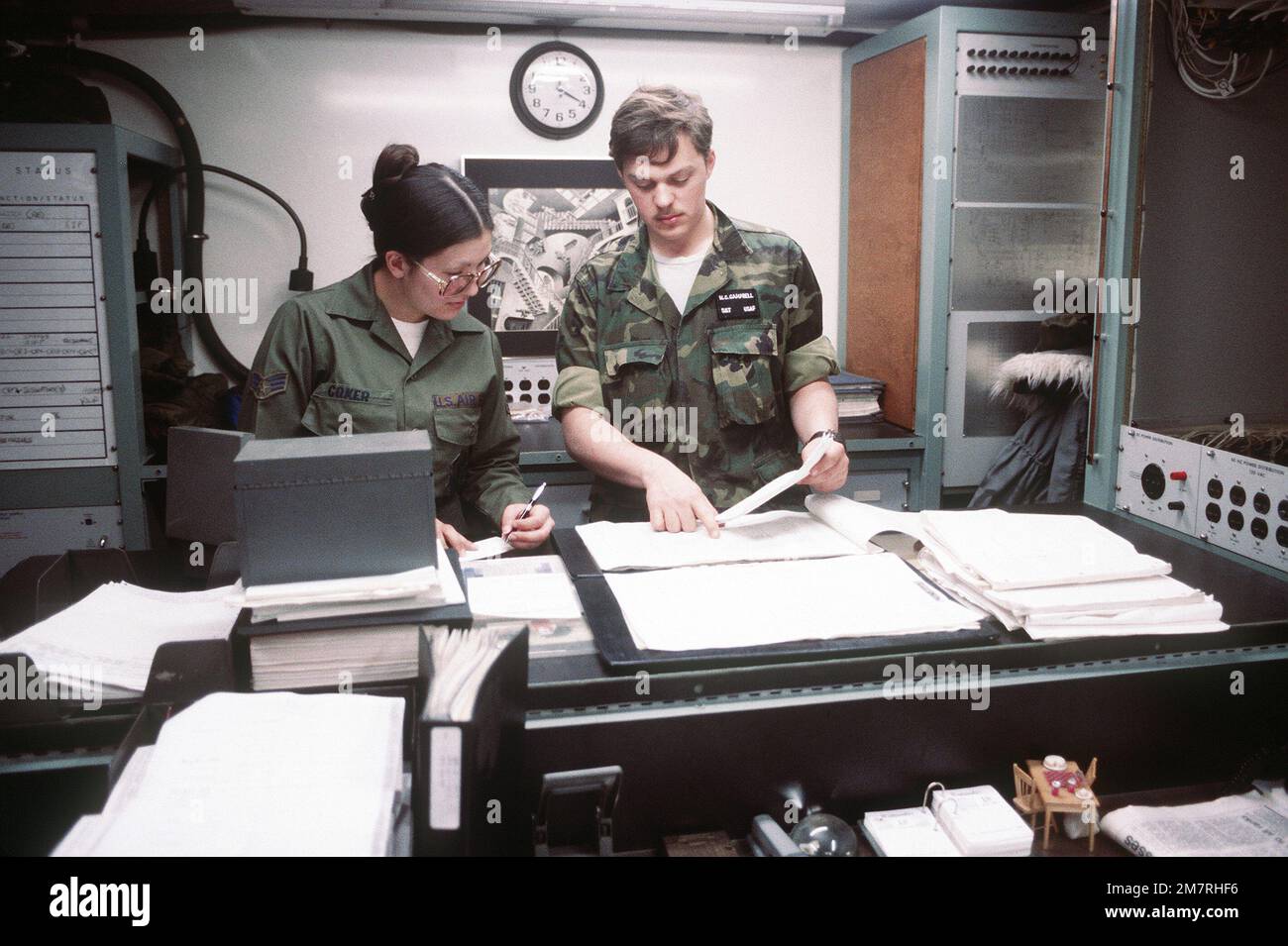 SRA Dorothy A. Coker and SGT Wayne C. Campbell go over computer run ...