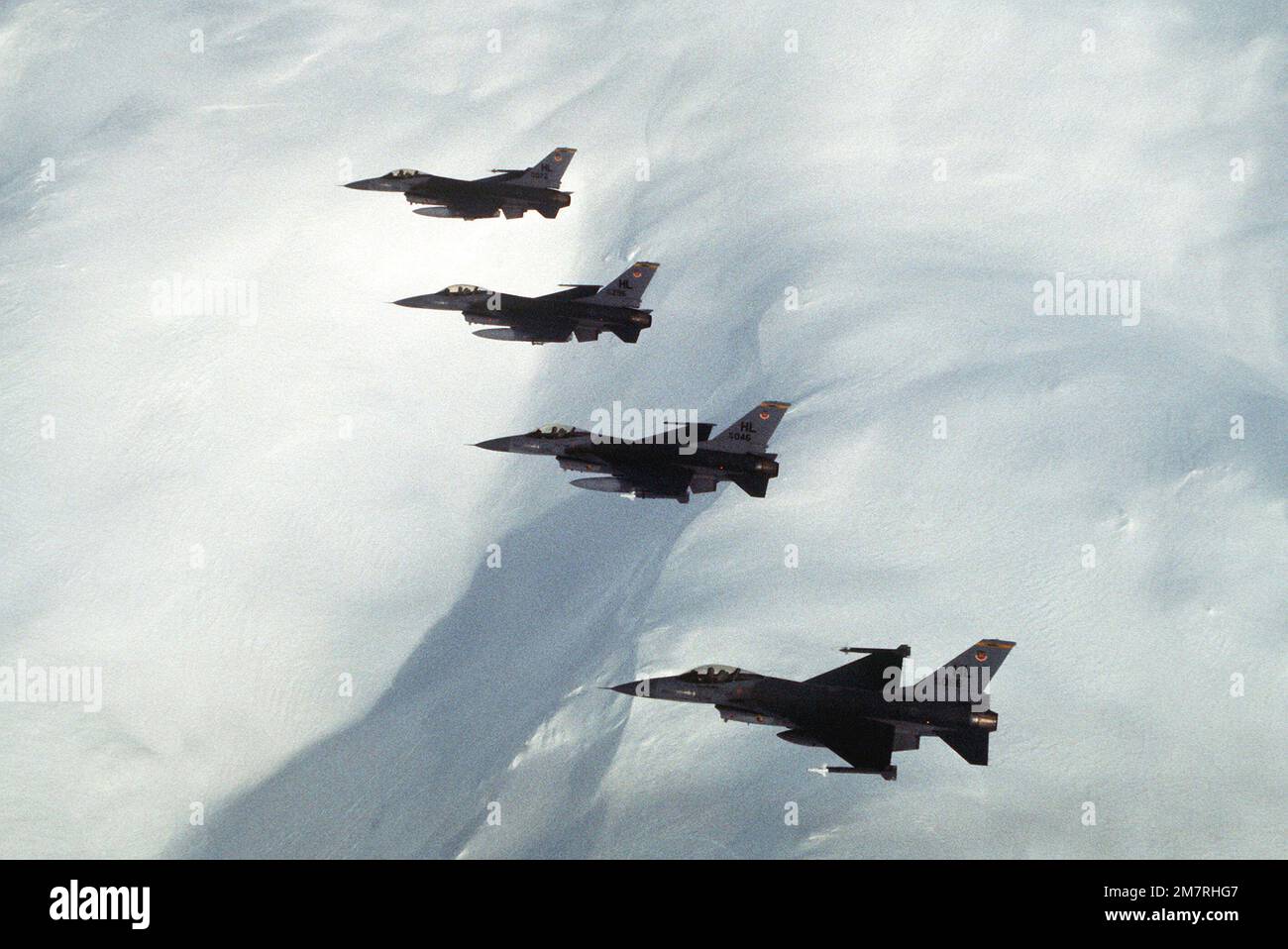 AN air-to-air left side view of four F-16 Fighting Falcon aircraft from ...