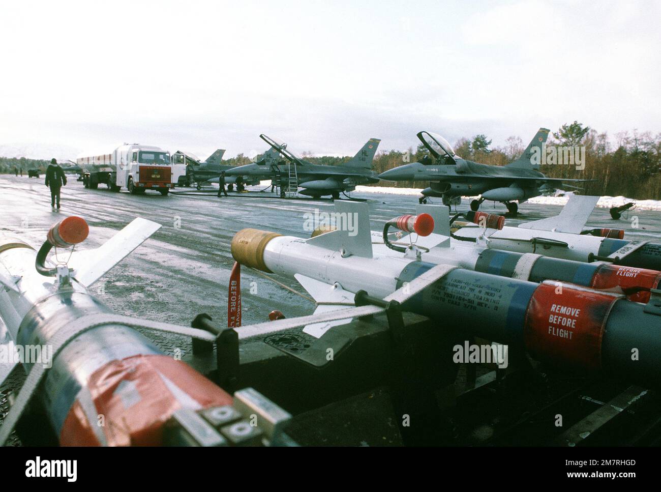 A row of AIM-9 Sidewinder air-to-air missile systems wait to be loaded ...