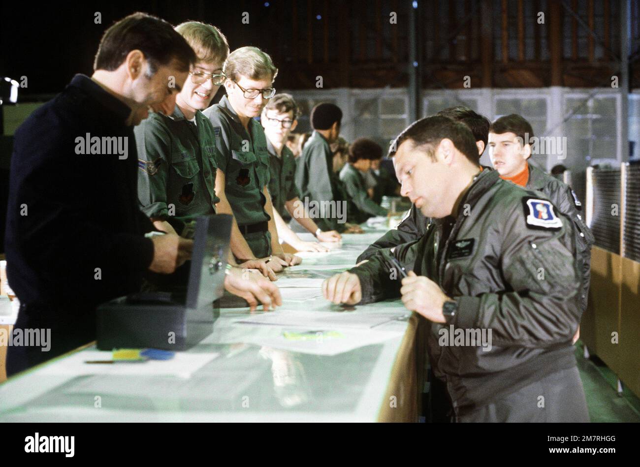 Airmen and noncommissioned officers fill out flight debriefing forms ...