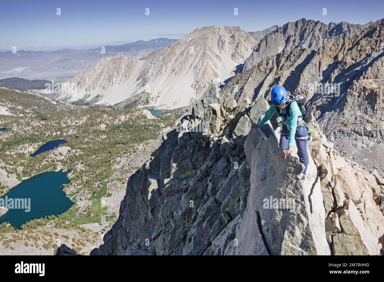 woman scrambling up the steep mountain ridge on Two Eagle Peak in the ...