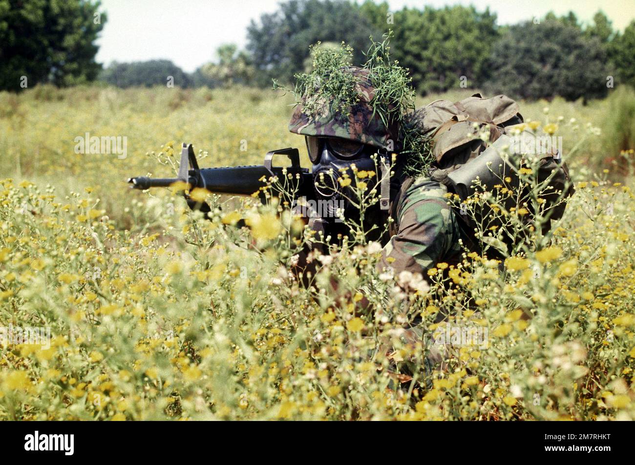 A Marine equipped with an M-16A1 rifle, backpack, field protective mask ...