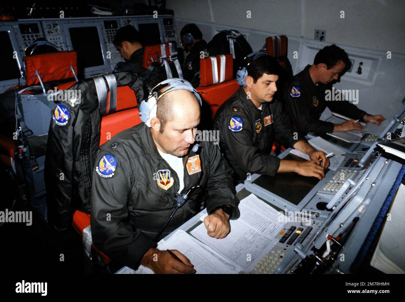Crewmen monitor control panels aboard an E-3A Sentry Airborne Warning ...