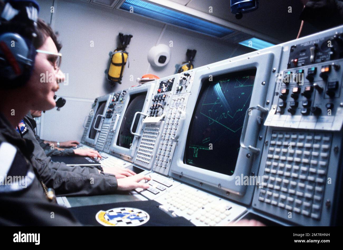 A crewman monitors a radar scope aboard an E-3A Sentry Airborne Warning ...
