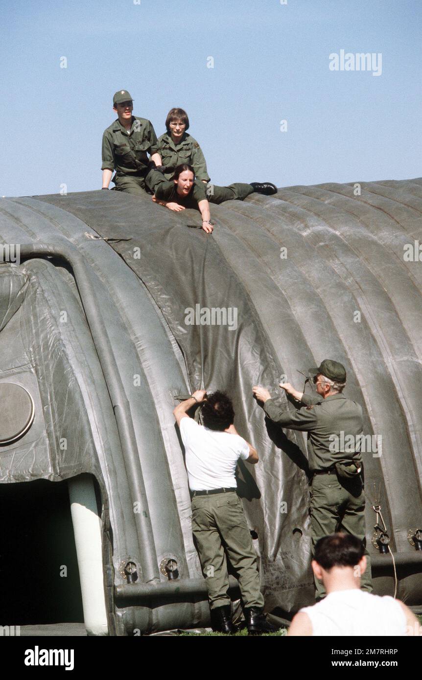 Airmen latch sections of a tent together after the tent is inflated ...
