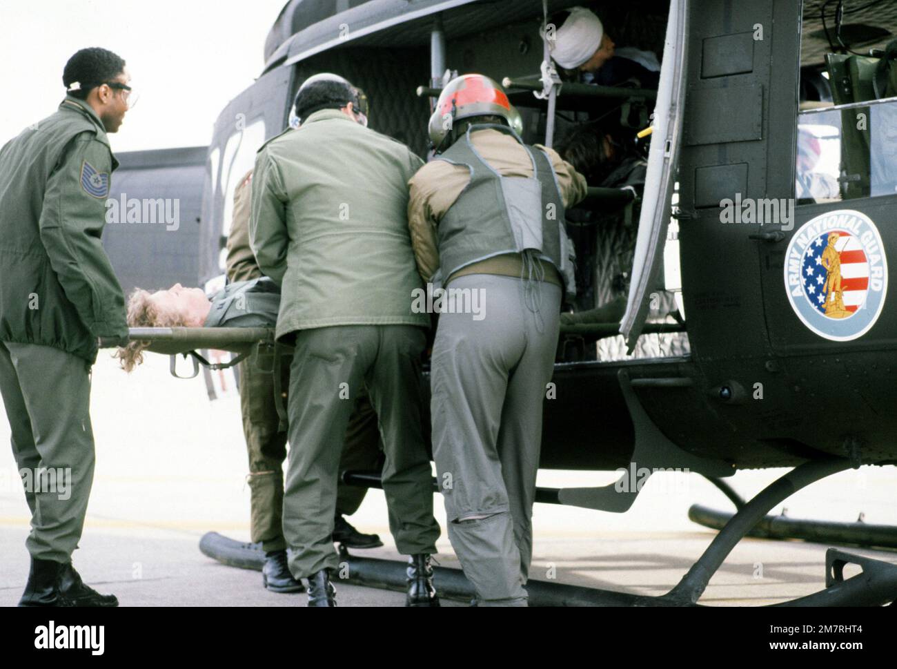 Airmen load a "patient" aboard a UH-1N Iroquois helicopter during an ...